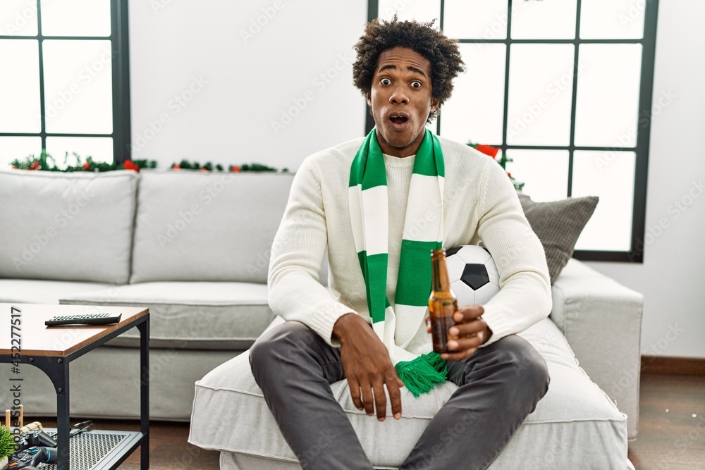 Young african american man football hooligan drinking beer cheering ...