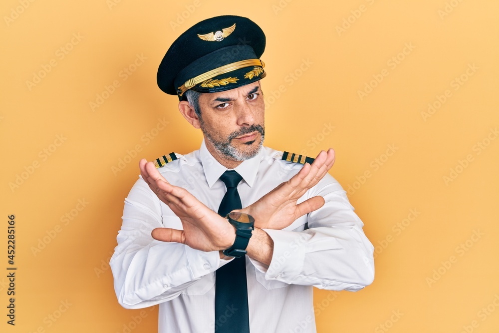 Handsome middle age man with grey hair wearing airplane pilot uniform ...