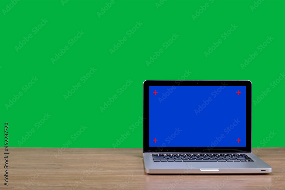 Blue screen laptop computer sitting on wooden desk with chroma key ...