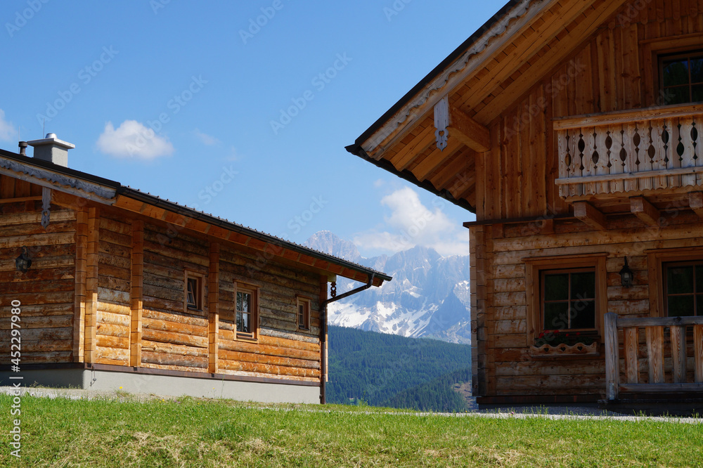 beautiful alpine panorama with alpine log cabins and Dachstein mountain ...