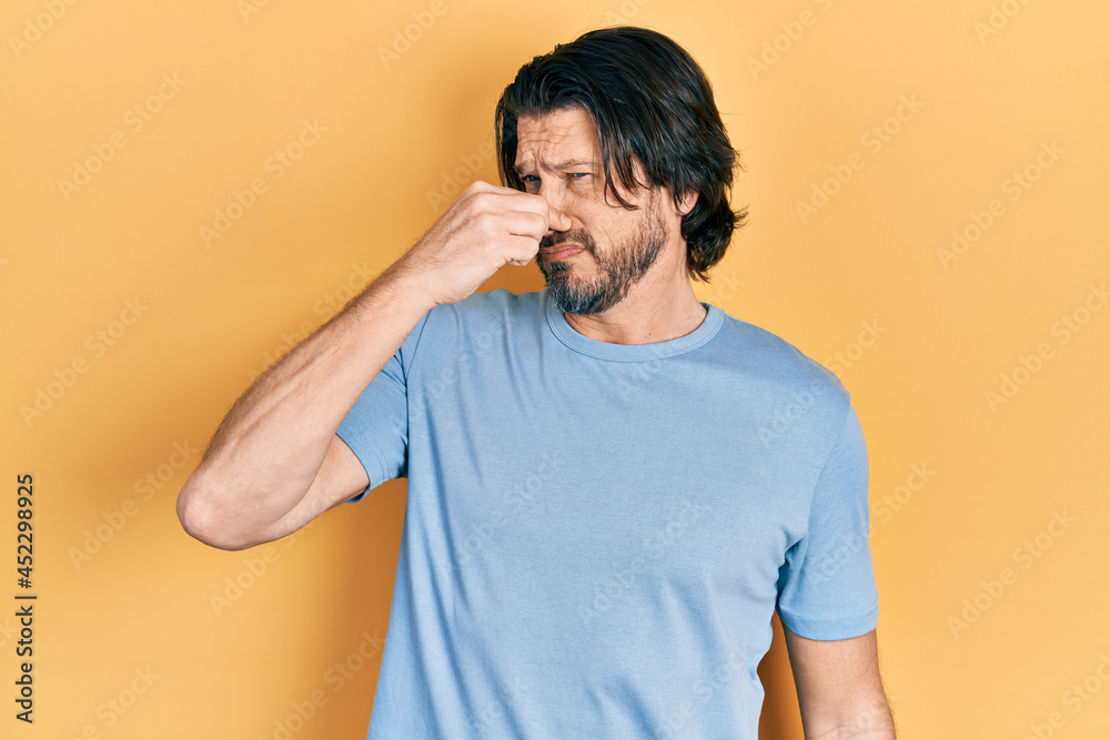 Middle age caucasian man wearing casual clothes smelling something ...