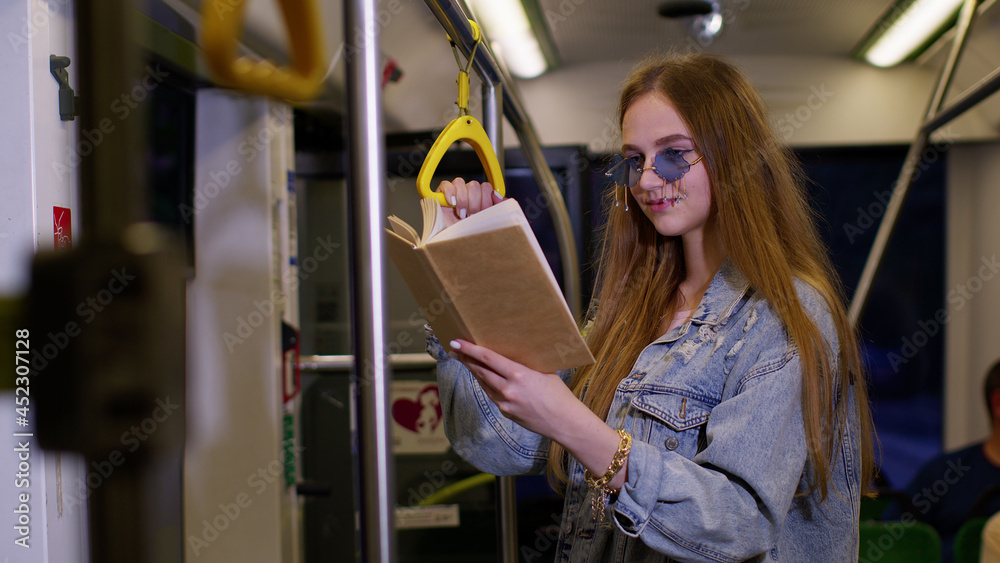 Portrait of attractive young adult woman stay at empty subway train and ...