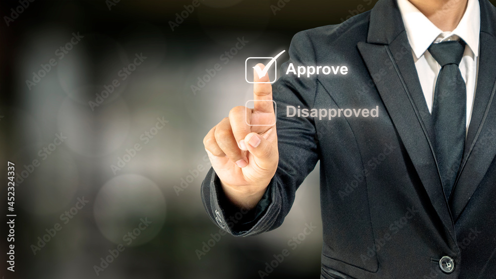 Close-up of human hand-selecting checkbox labeled approved over blurred ...