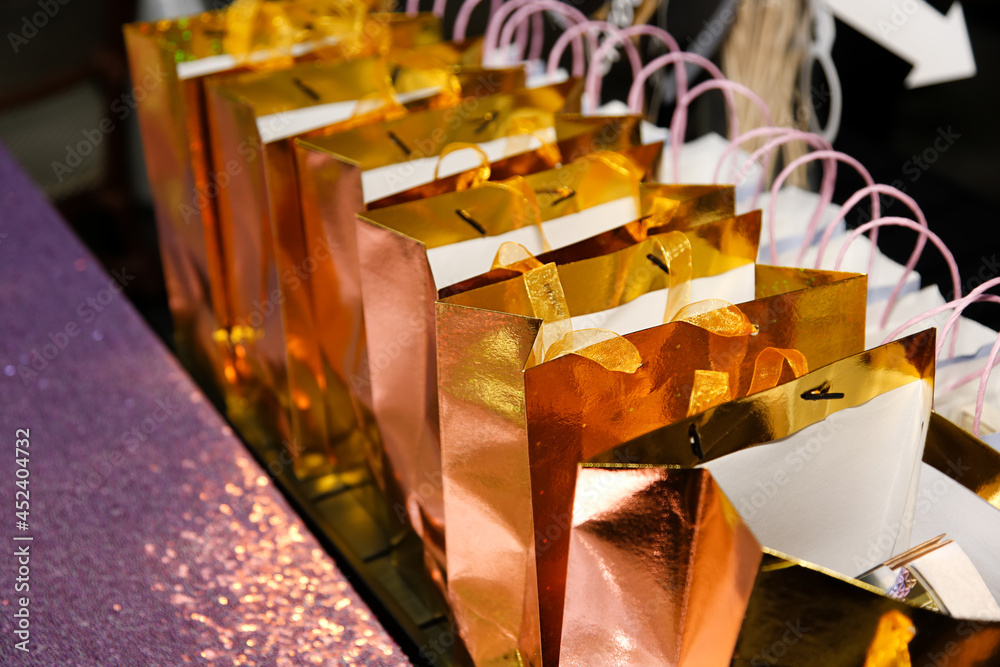 A view of several golden goodie bags on a table, seen at a reception ...