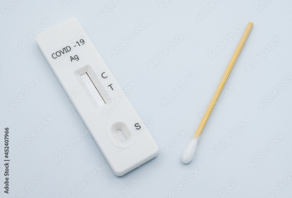 A rapid antigen test pad with short cotton swab on white background ...