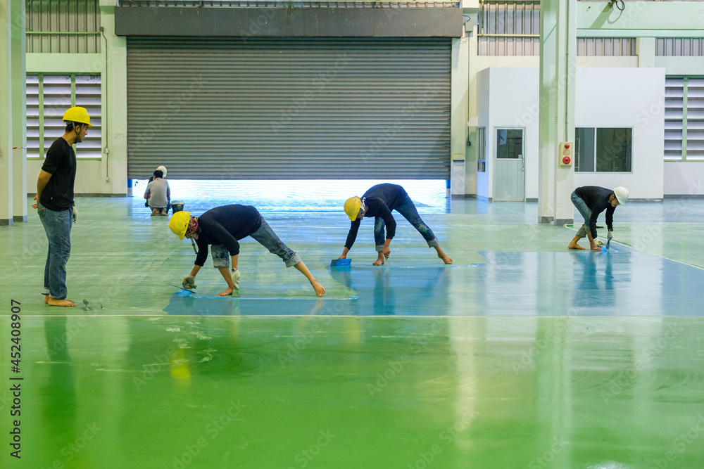 Fotka „Construction workers are using trowel spreading epoxy putty for ...