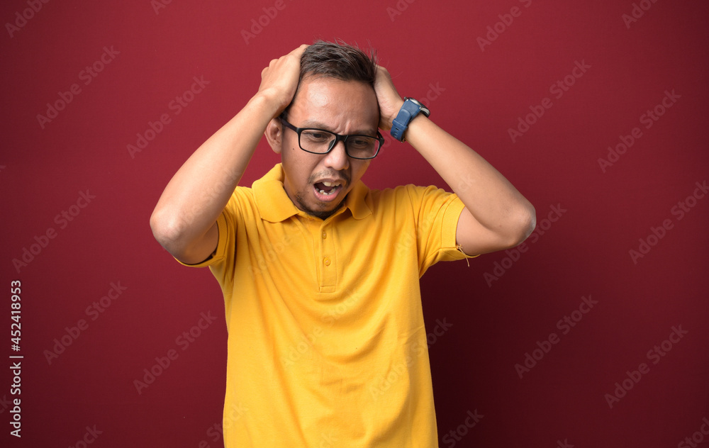 Young Asian man stressed with hand on head shocked with shame and ...