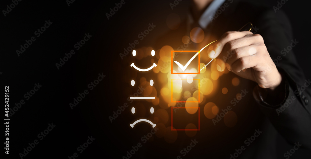 Businessman holding digital with a checked box on excellent smiley face ...