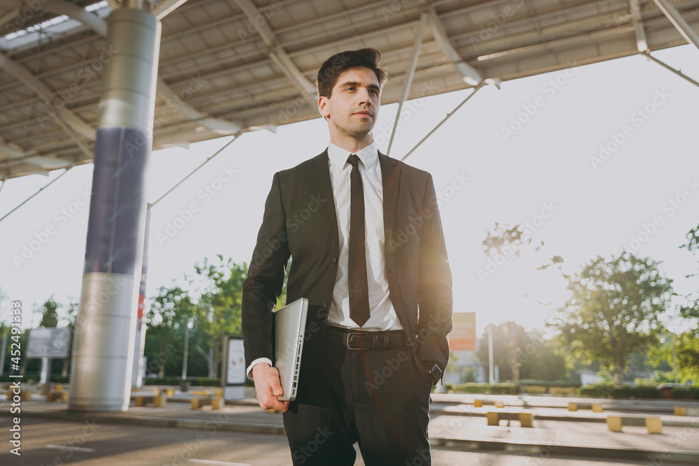 Bottom view sunlit minded young traveler businessman man in black suit ...