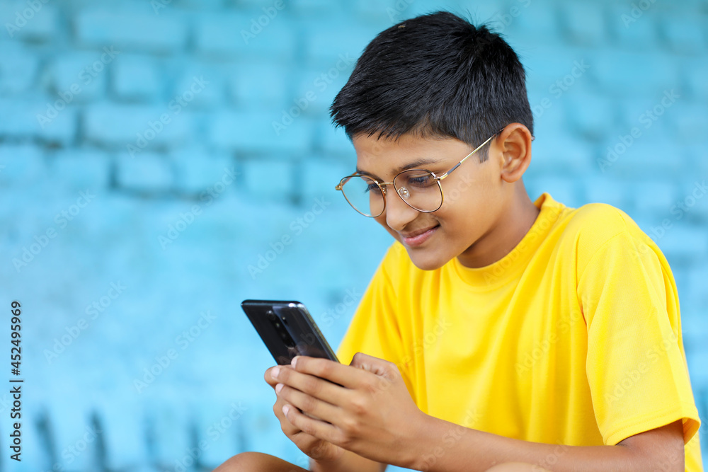 Cute Indian child using smartphone. online education concept Stock ...