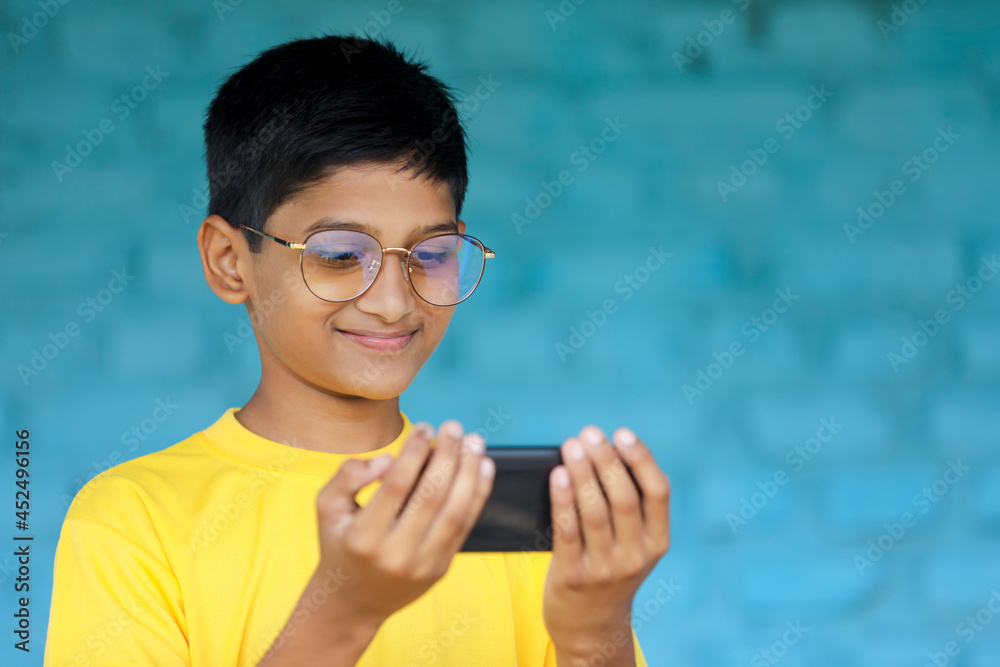 Cute Indian child using smartphone. online education concept Stock ...