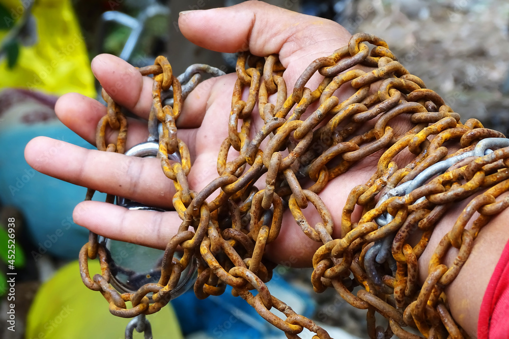 Hands with chain wrapped around them , A brass padlock and background ...