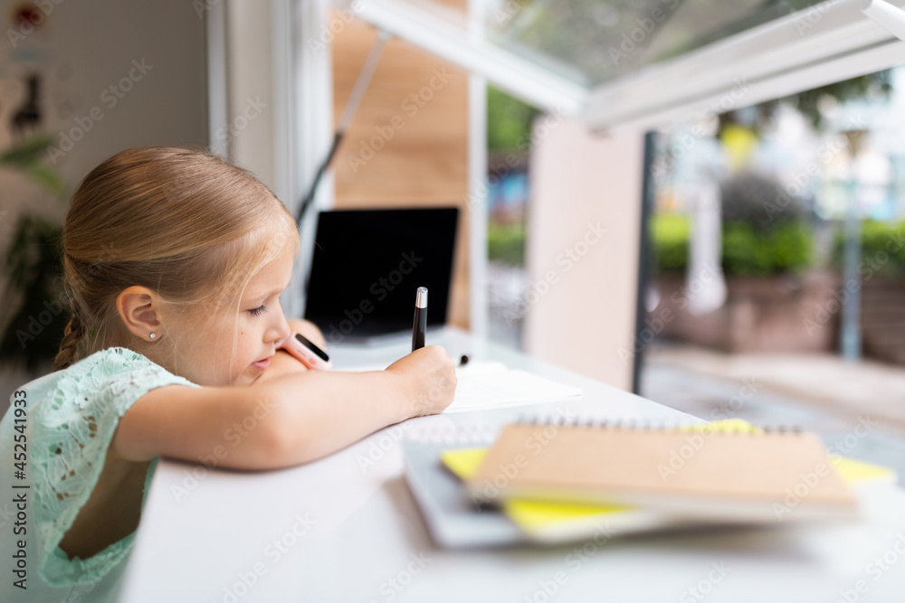 happy caucasian kid has online lesson on laptop during coronavirus ...