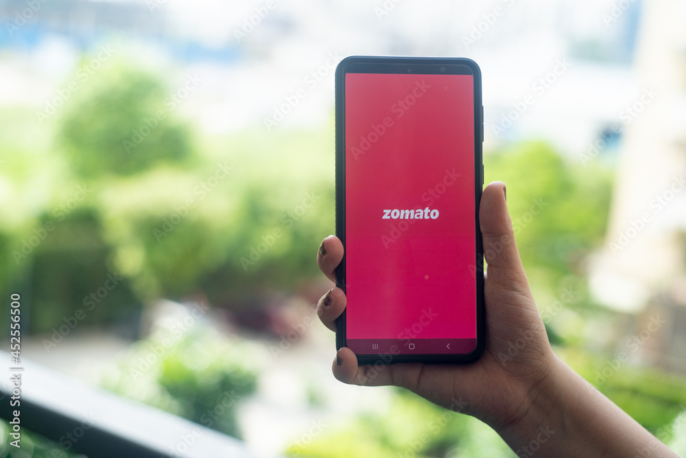 hand holding a mobile phone with zomato app logo showing this food tech ...