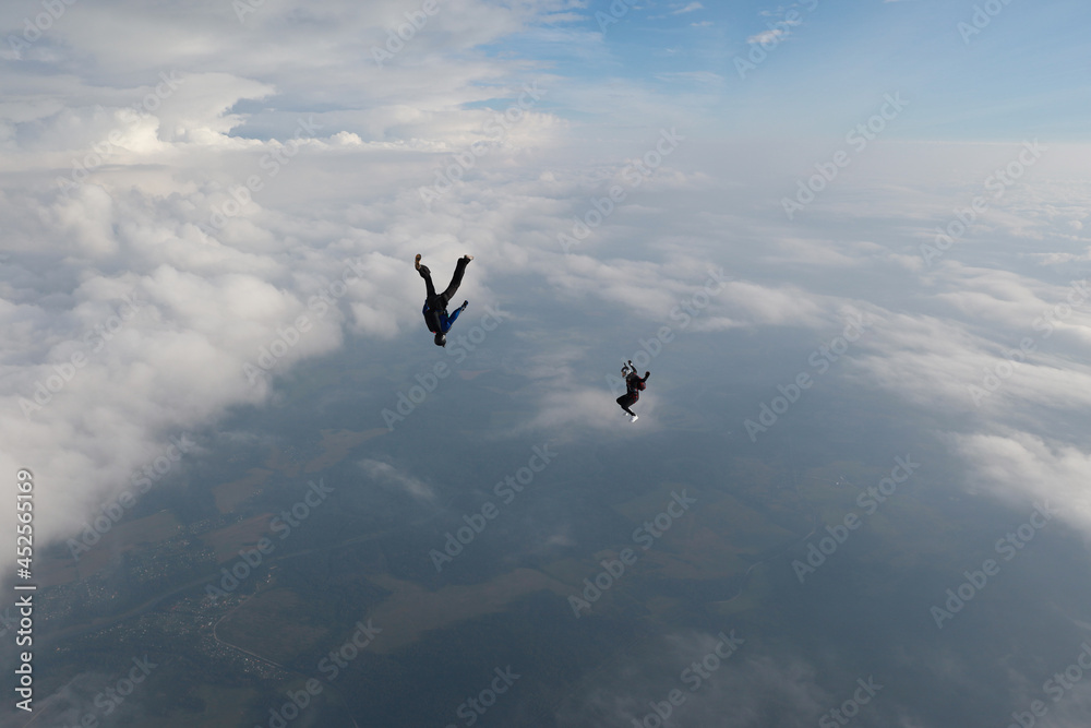 Skydiving. Freefly jump. Two guys are faling in the cloudy sky. Stock ...