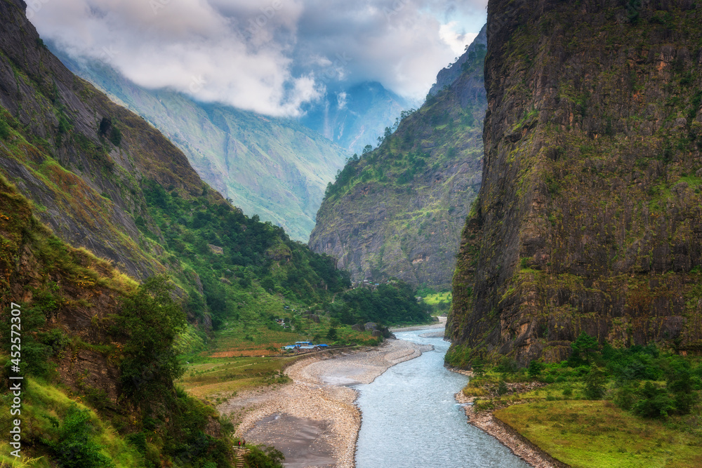 Small village on the river coast in Himalayan mountains. Beautiful ...