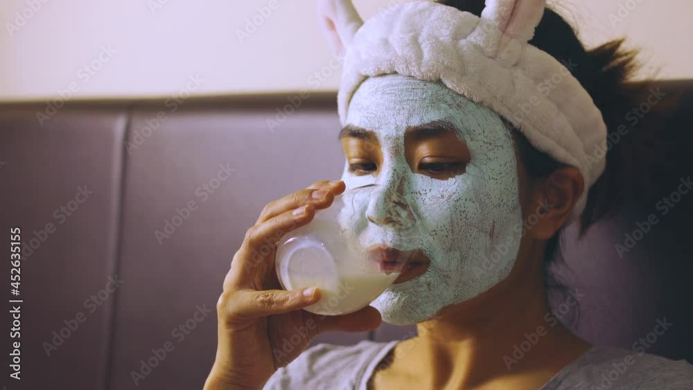 Face focusing of medium aged asian woman who is masking face with mud ...