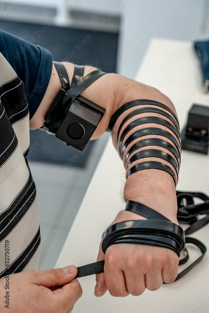 Religious jew places a black leather tefillin on his left hand with a ...