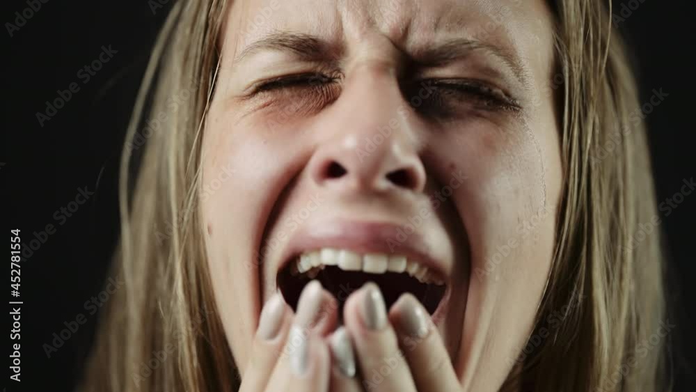 A sad beaten up woman with tear in eye and bruises is crying or ...