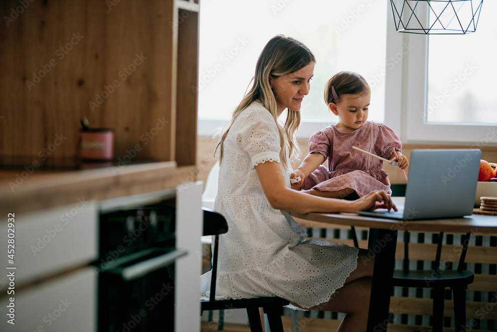 Stay at mother home sitting in kitchen and getting work done while her ...
