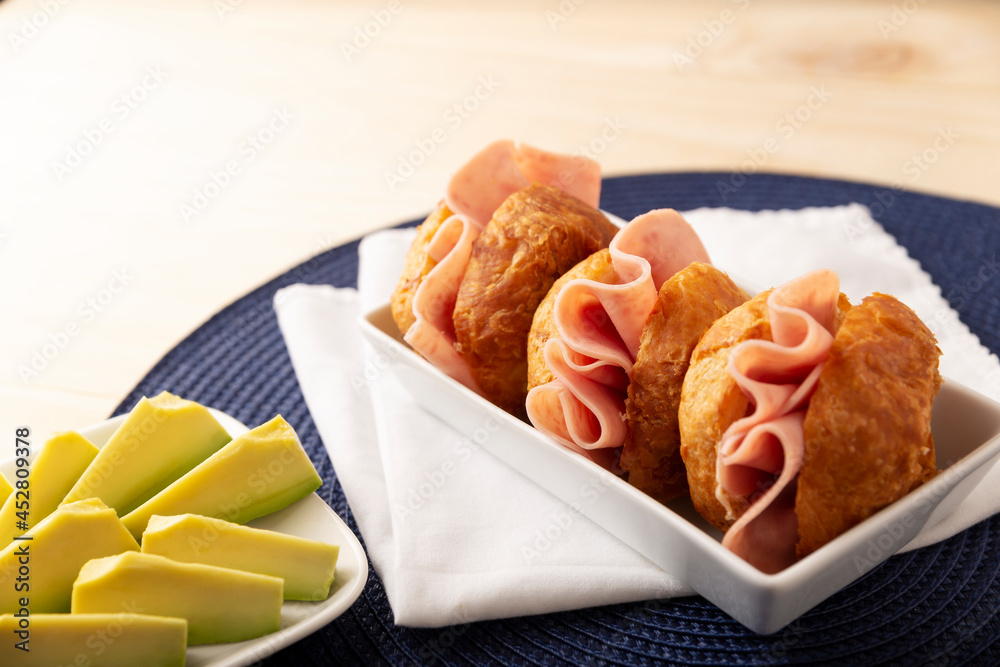 Mini ham sandwich made with "Hojaldra" accompanied by sliced avocado ...