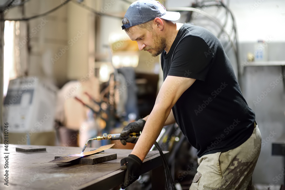 Metalwork craftsman making handmade lamp at workshop. Man worker is ...