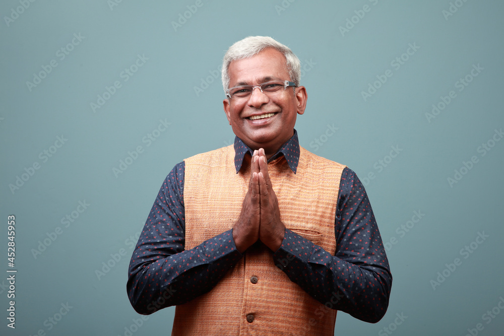 Happy smiling Indian elderly man shows a 'Namaskar' gesture Stock Photo | Adobe Stock