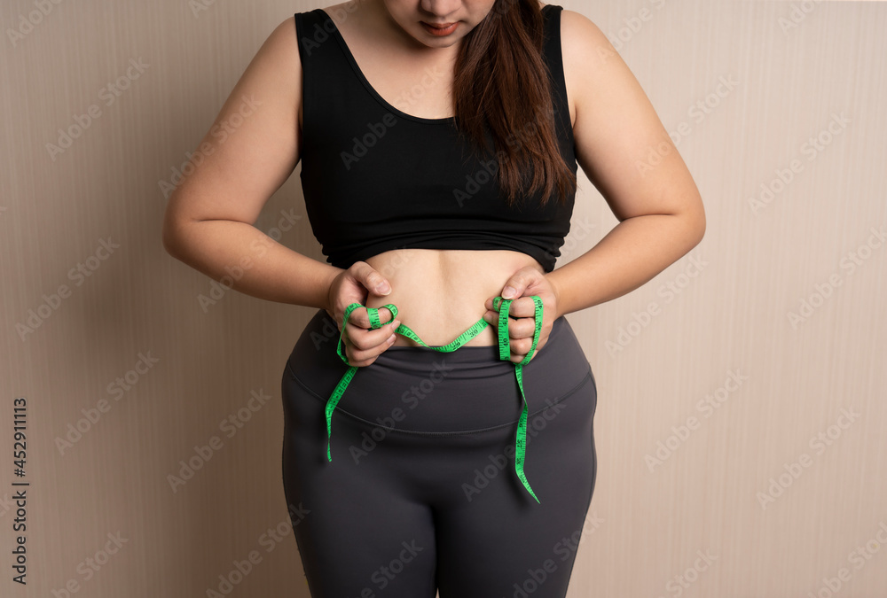 Stockfoto beautiful fat woman in sportswear catches her big belly or ...