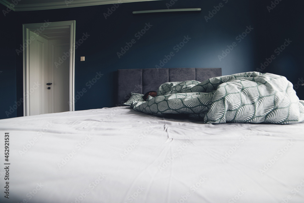 Man sleeping in the bed at home. Dark blue color bedroom interior ...