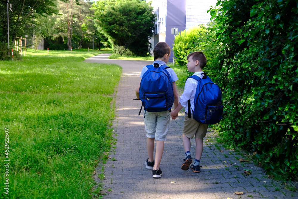 two boys, ,primary school students, children with blue school bags ...