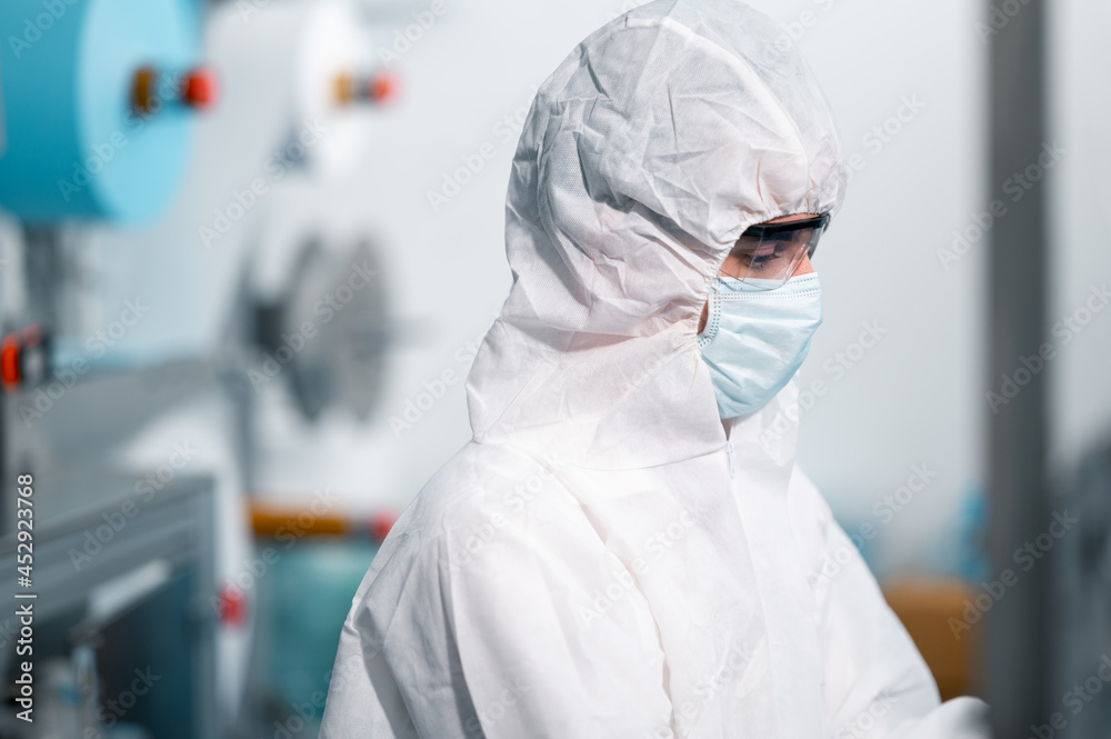 Scientists wearing protective clothing Inspect mask making machines in ...