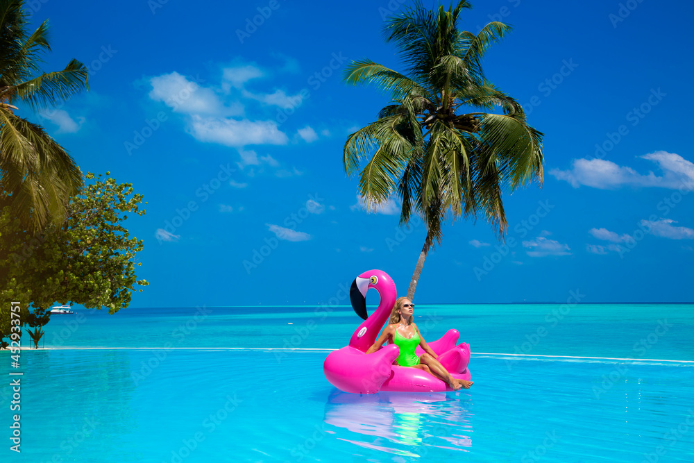 Beautiful Sexy Tanned Woman Bikini Model On Pink Flamingo In Pool