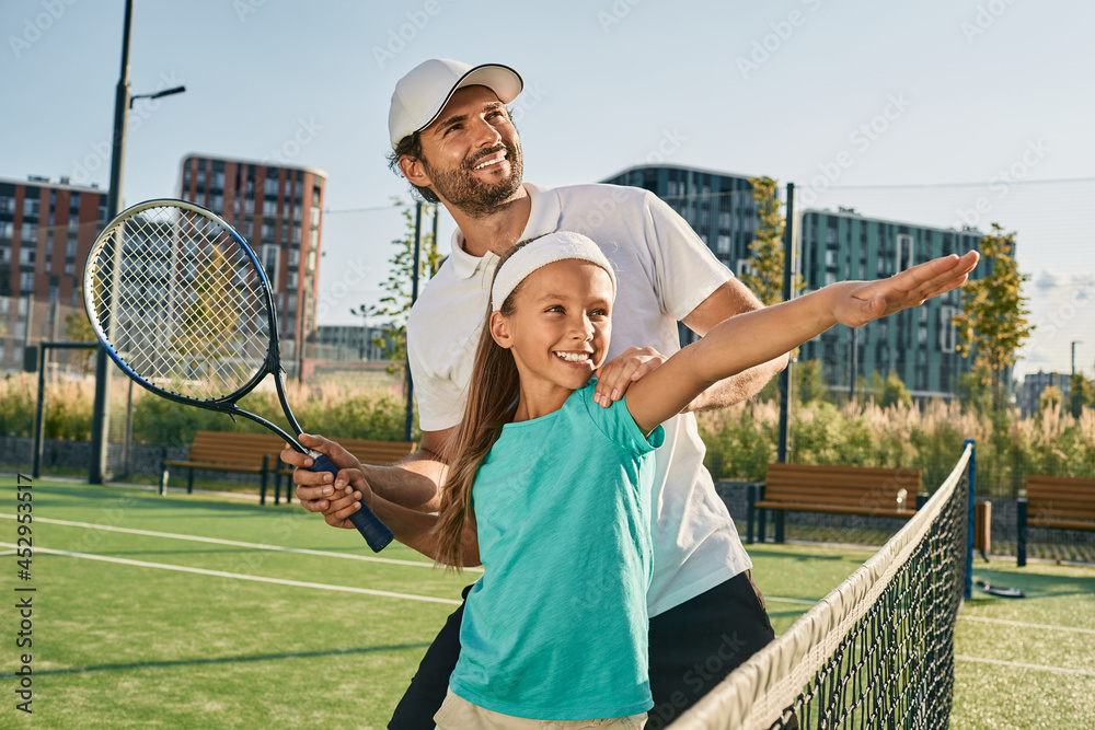 Tennis lesson for a child. Tennis coach teaches little girl to play ...