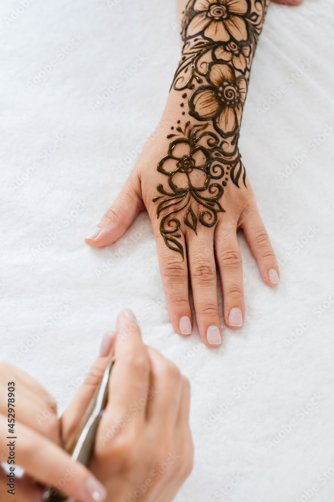 Top view art henna tattoo on woman hands. master artist drawing Arabic ...