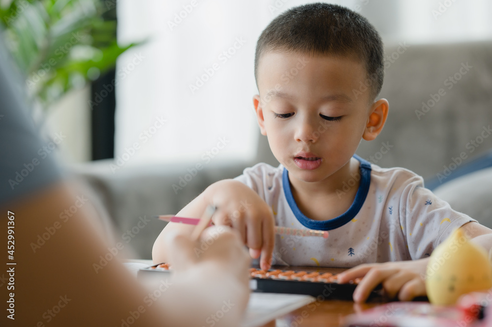 Asian child boy Learning math with an abacus, education concept, home ...