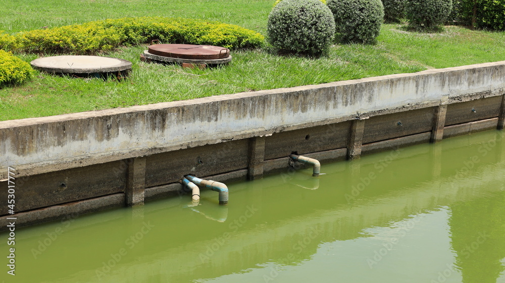 Poolside pipes. PVC pipes are embedded in the side of the concrete pond ...