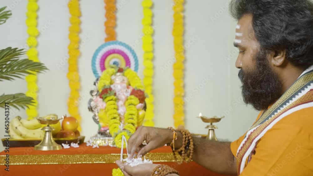 holy guru or priest offering flowers to lord Vignesh or ganesh during ...