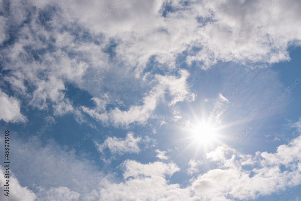 Rays of sunshine breaks through the dark clouds. Sun and blue sky with ...