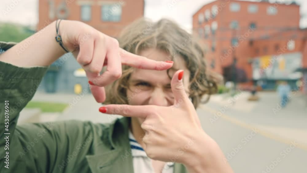 Cute happy young woman look into camera, make photo frame gesture with ...