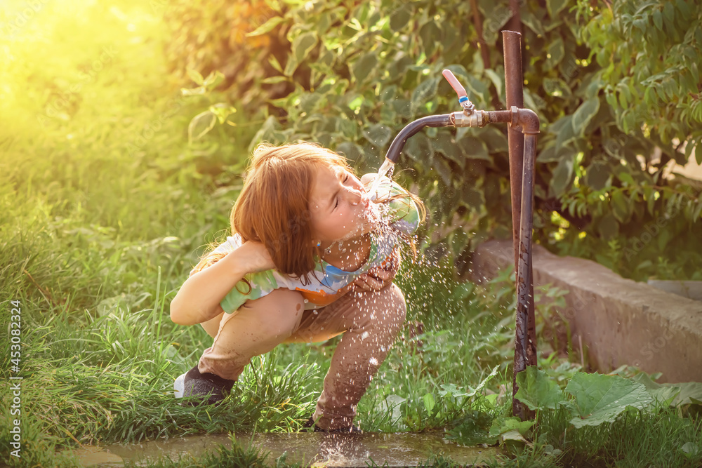 cute girl drinking water from the tap outdoors Stock Photo | Adobe Stock