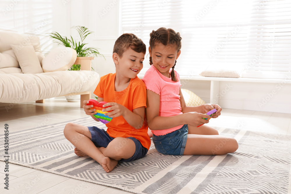 Children playing with pop it fidget toys on floor at home Stock Photo ...