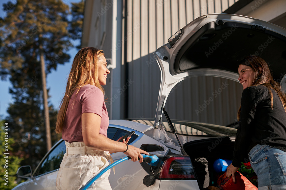 Women talking in front of car Stock Photo | Adobe Stock