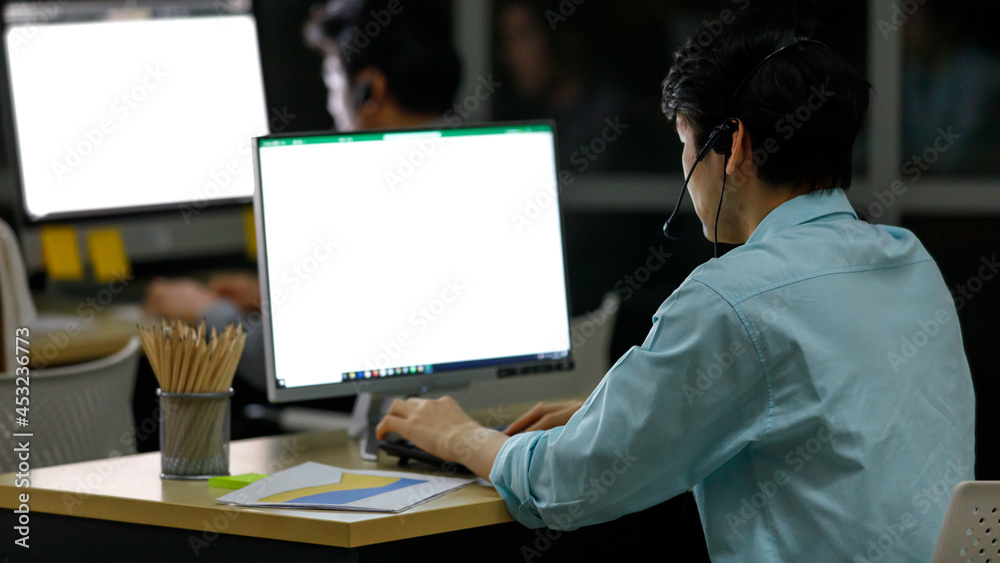 Behind Asian adult man is help desk call center do work at night to ...