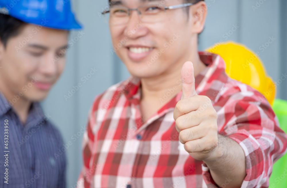 Young construction workers smiling with giving thumbs up as sign of ...