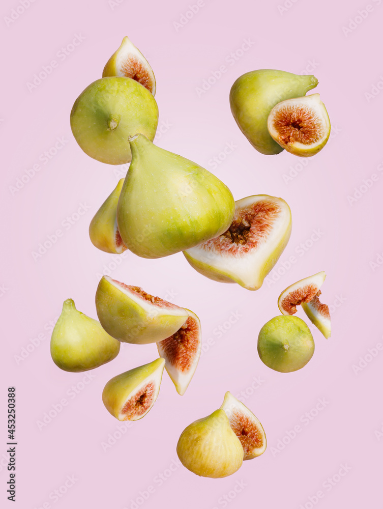 Juicy green figs slices thrown in the air falling down and flying ...