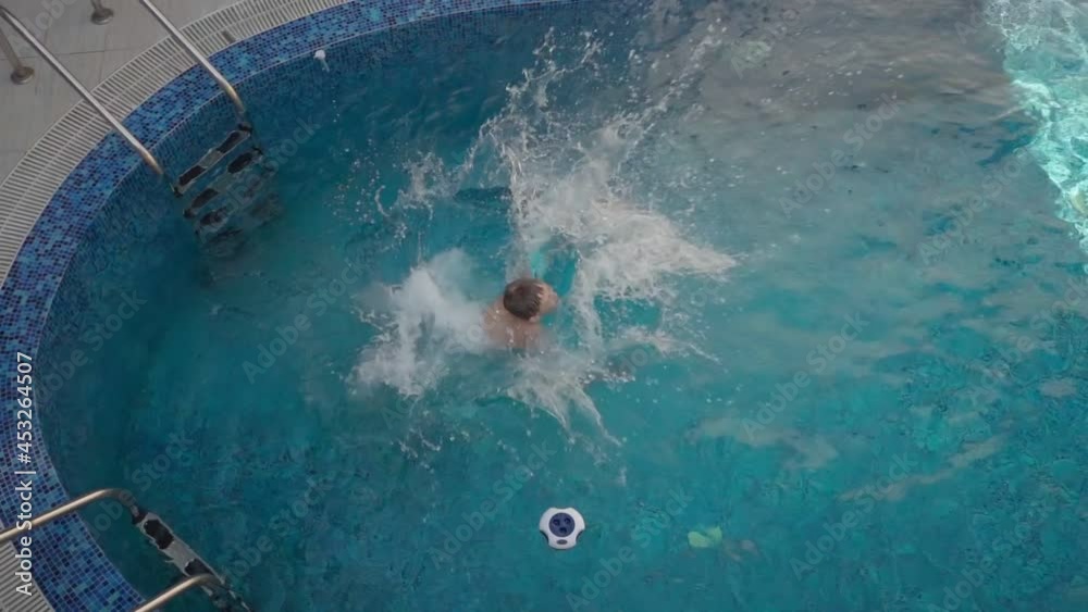 boy jumps into pool top view. Jump into water in swimming pool, Splash ...