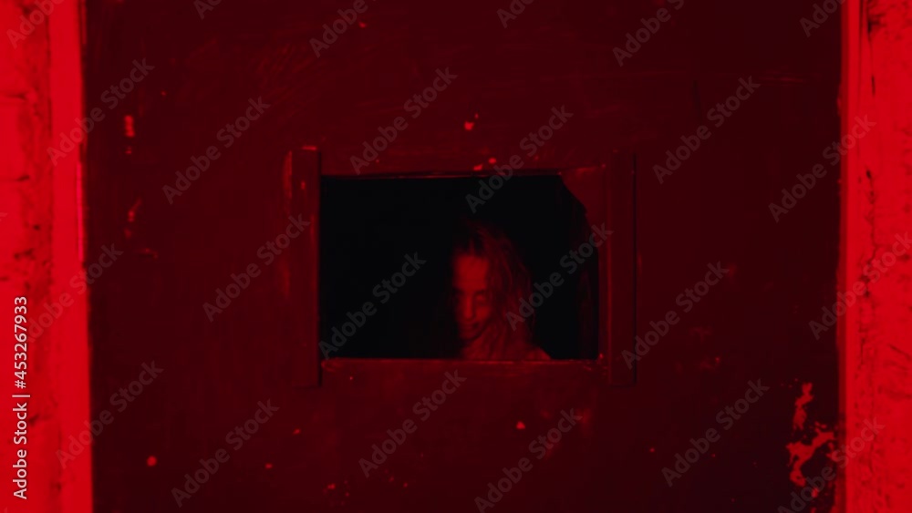 Horror acting - a woman in a straitjacket standing behind the door in ...