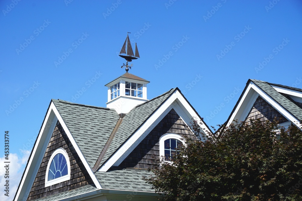 Vintage sailing ship weather vane atop a classic cupola at the peak of ...