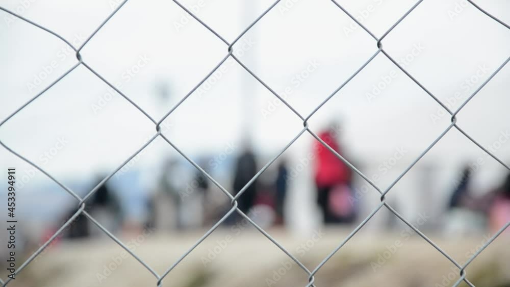 Barbed wire in refugee camp. Migrants behind chain link fence in camp ...