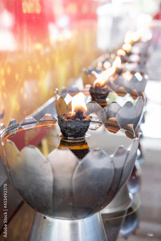 Burning yellow candle flame, Oil filling in Thai style metal candle in ...